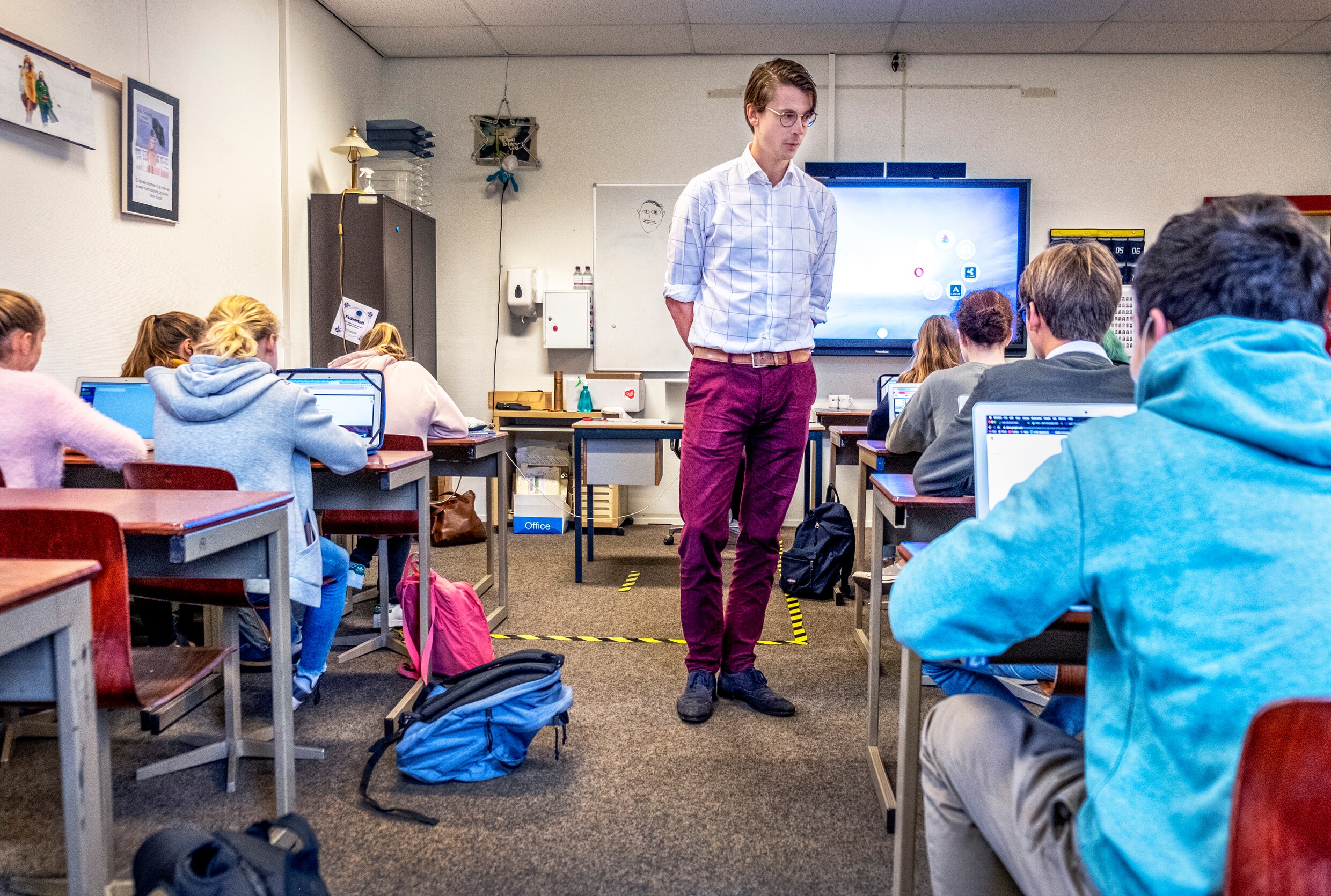 Snotterige leraar geeft les vanuit huis terwijl een student de klas in ...