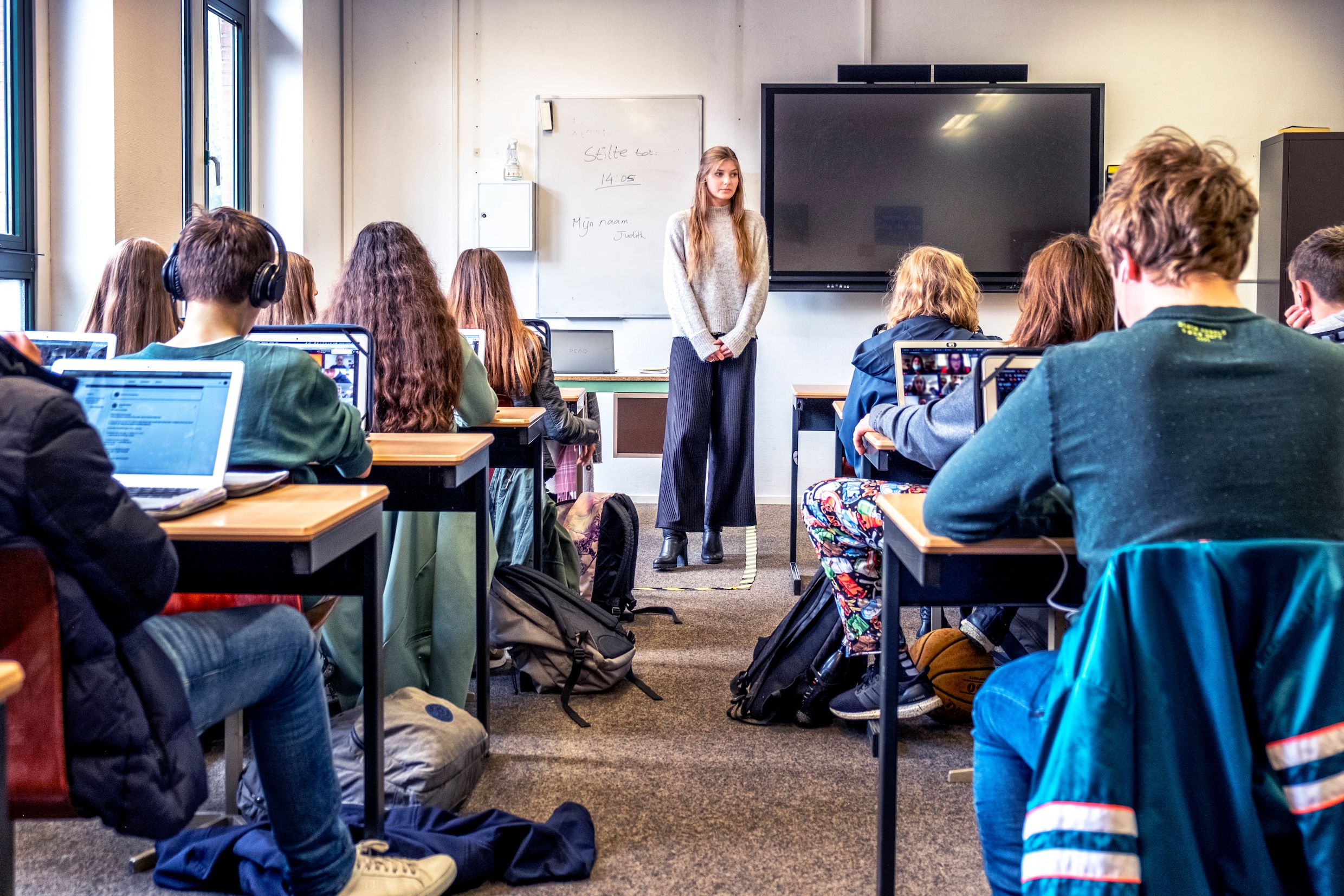 Snotterige leraar geeft les vanuit huis terwijl een student de klas in ...