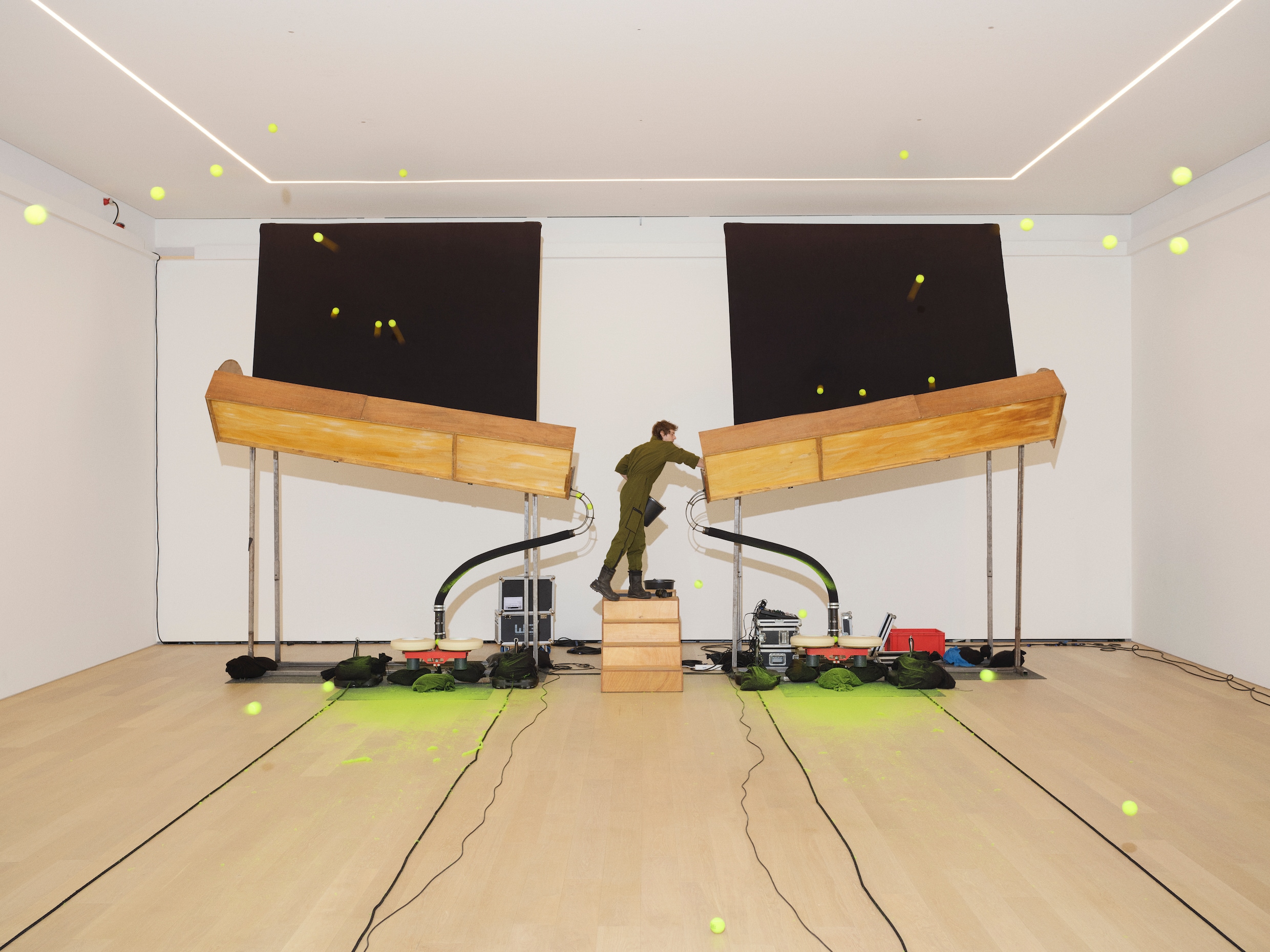 Een spectaculaire machine schiet tennisballen af op twee klankkasten ...